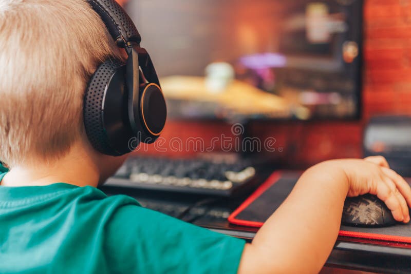 Little Boy Playing Games on Computer in Headphones with Microphone ...