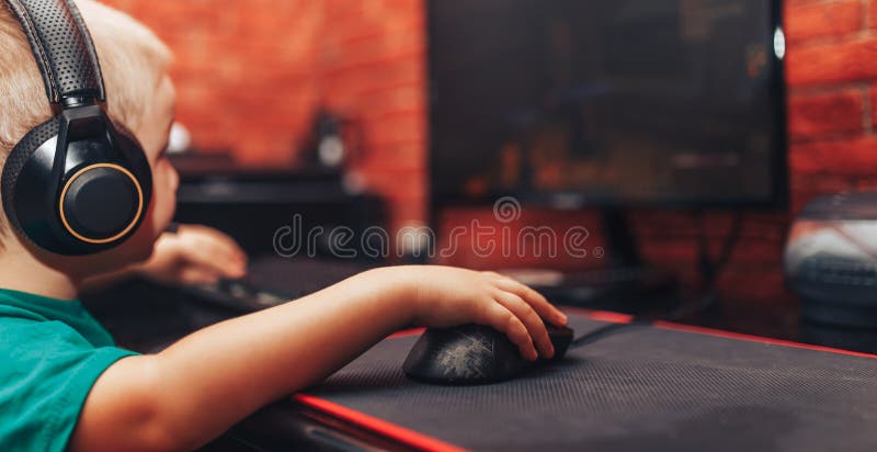 Little Boy Playing Games on Computer in Headphones with Microphone ...