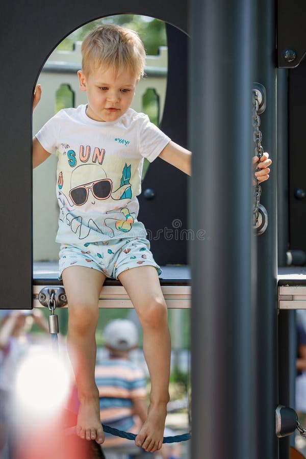 The Little Boy is Playing on a Modern Playground. the Child Climbs ...