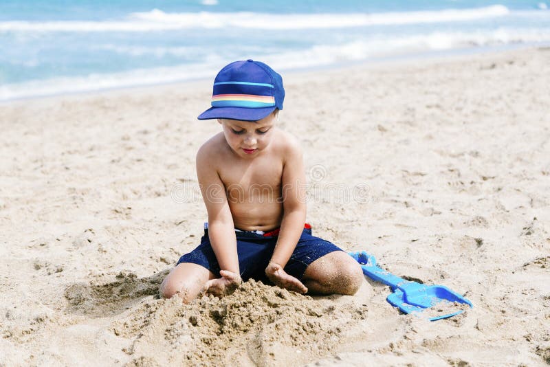 Little Boy Playing with the Sand in the Beach Stock Photo - Image of ...