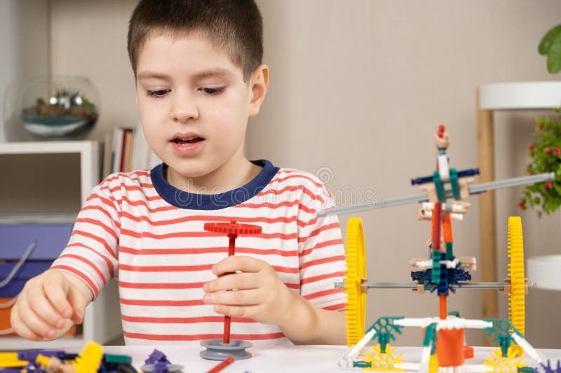 A Little Boy Plays with a Constructor, Creating Figures from Gears and ...