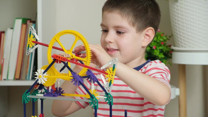 A Little Boy Plays with a Constructor, Creating Figures from Gears and ...