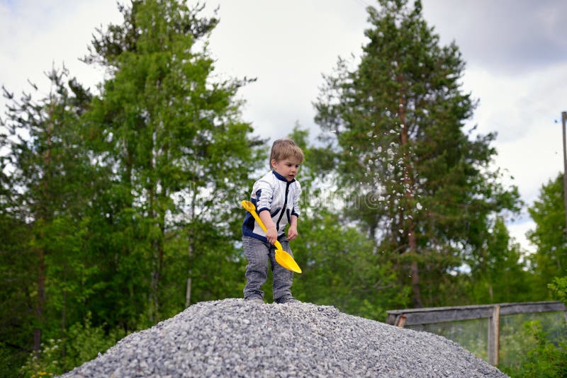 Little Boy Plays on Heap of Crushed Stone Stock Image - Image of field ...