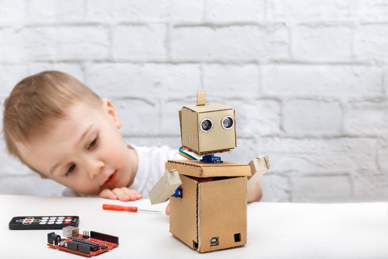 Little Boy Plays with the Robot at Home. Child Exploring Robot Stock ...