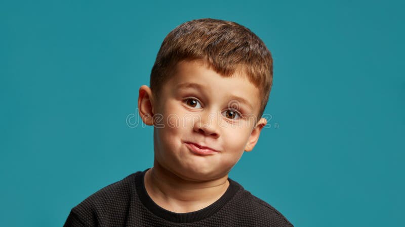 Little Boy Pulls Playful Face, Smirk with His Lips Puckered, Giving ...