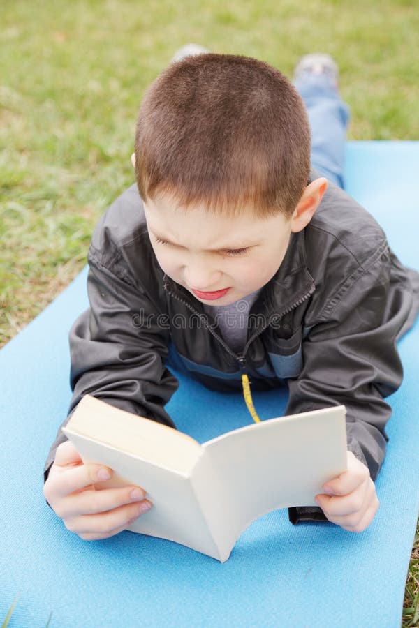 Little boy reading book stock image. Image of meadow - 19367609