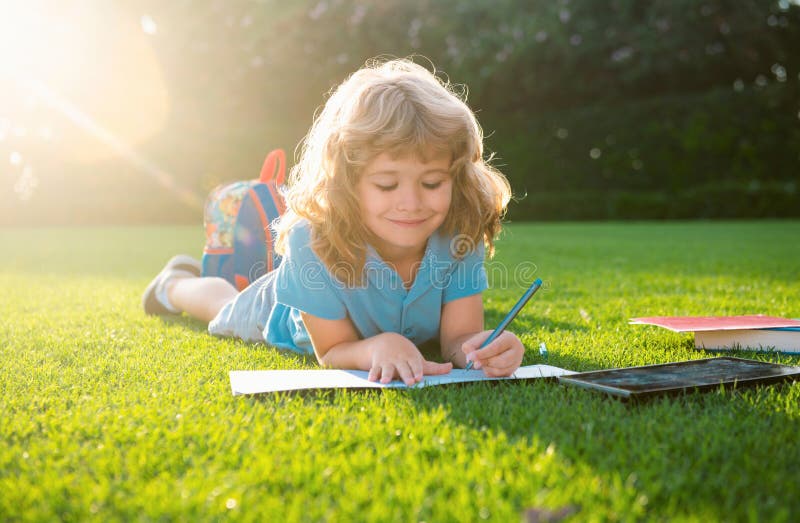 Little Boy Reading a Book and Writing Notes in Copybook in Summer ...