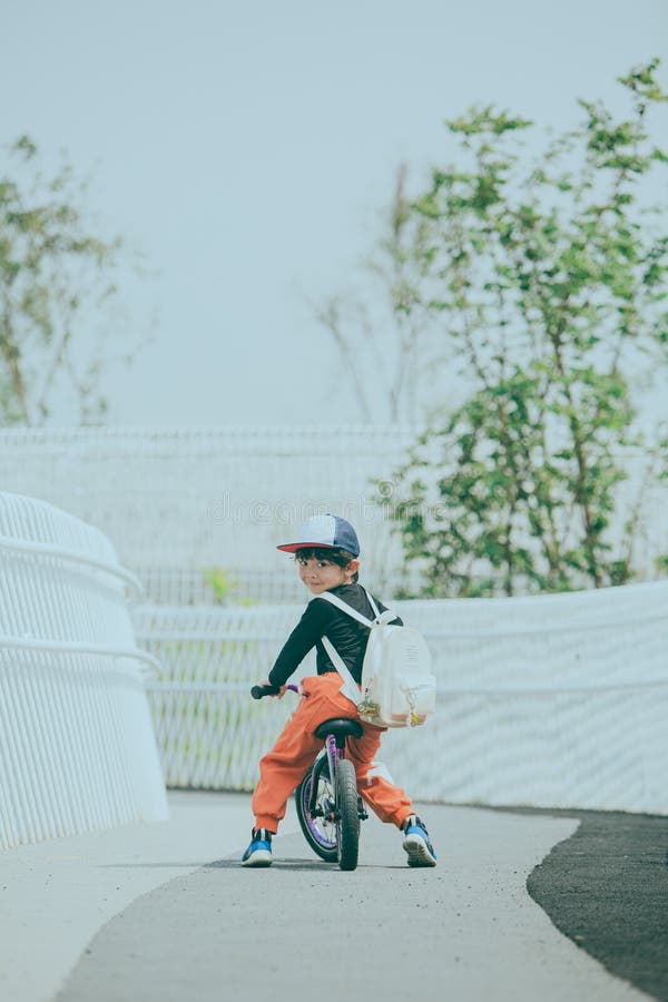 The Little Boy Riding a Bicycle is Looking Back Mischievously Stock ...