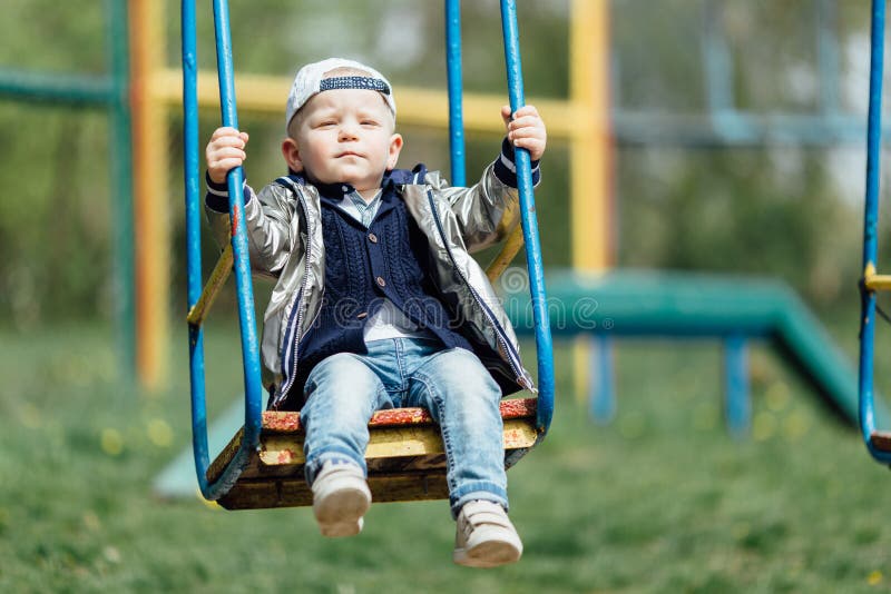 Little Boy Riding a Swing in Park Playground Stock Photo - Image of ...