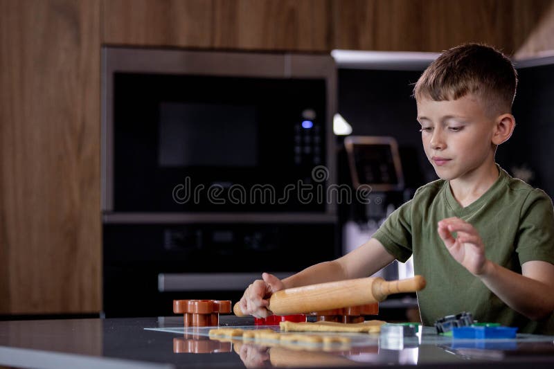 Little Boy Rolling Out Gingerbread Dough on the Table with a Rolling ...