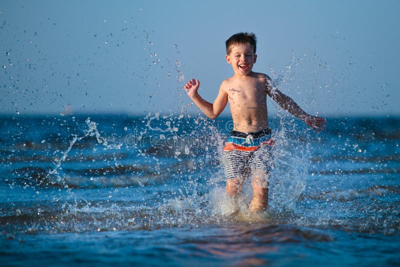 Little Boy Running through Water at the Beach Stock Photo - Image of ...