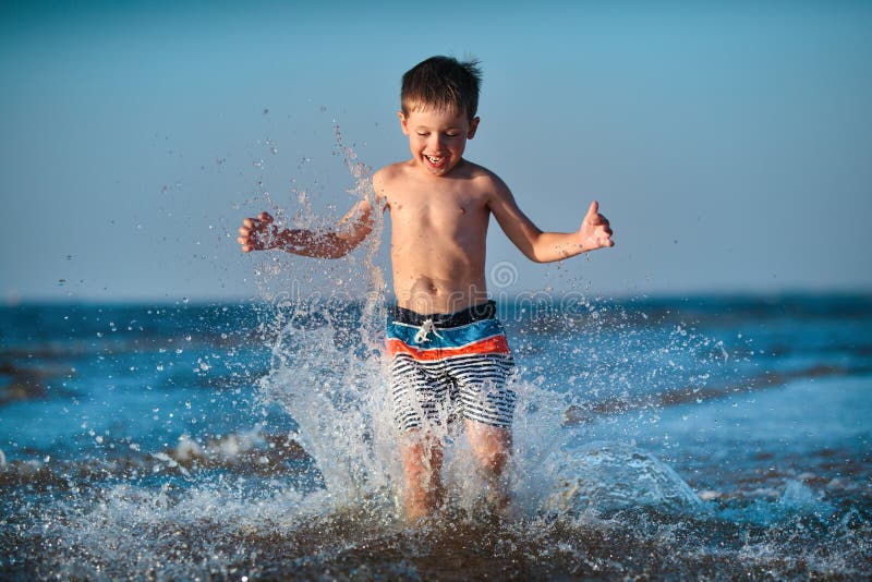 Little Boy Running through Water at the Beach Stock Photo - Image of ...