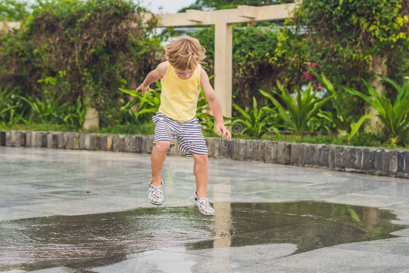 Little Boy Runs through a Puddle. Summer Outdoor Stock Photo - Image of ...