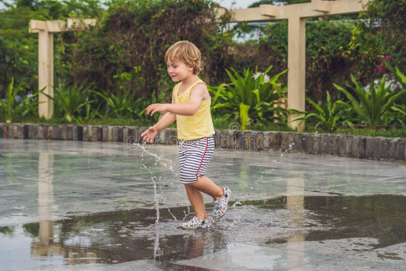 Little Boy Runs through a Puddle. Summer Outdoor Stock Photo - Image of ...