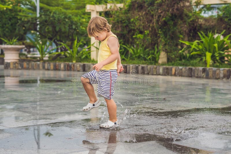 Little Boy Runs through a Puddle. Summer Outdoor Stock Photo - Image of ...
