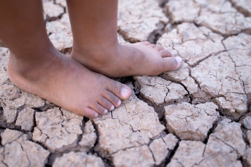 The Little Boy& X27;s Feet Stood on the Dry and Cracked Ground Stock ...