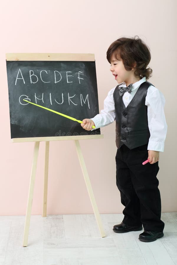 Little Boy Shows by Yellow Pointer Letters at Chalkboard Stock Image ...