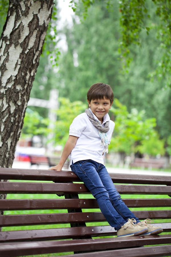 Little Boy Sitting on a Bench in a Summer Park Stock Image - Image of ...