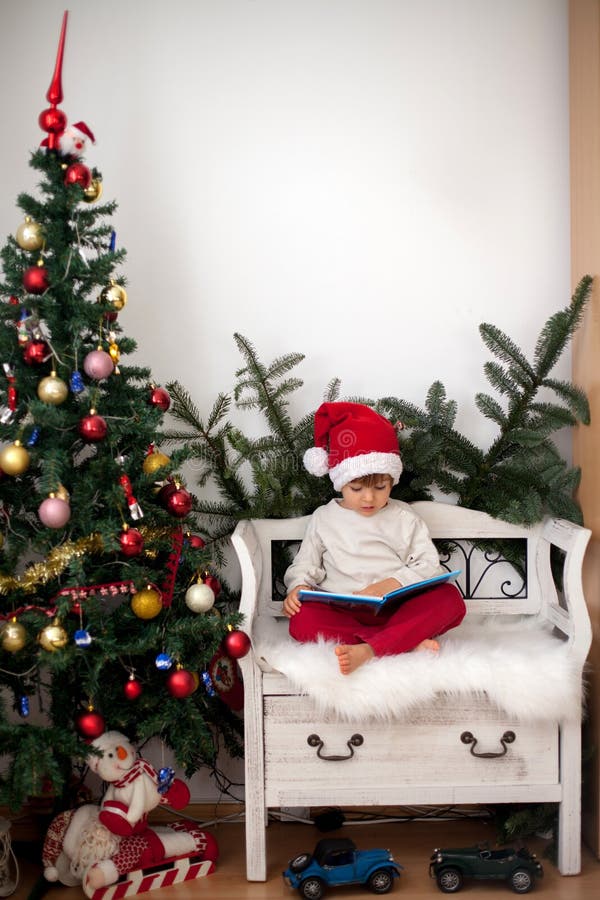Little Boy, Sitting on a Bench Under Christmas Tree, Eating Choc Stock ...