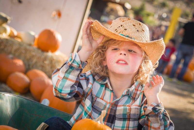 Little Boy Sitting with a Cowboy Hat in a Rustic Ranch Setting at the ...