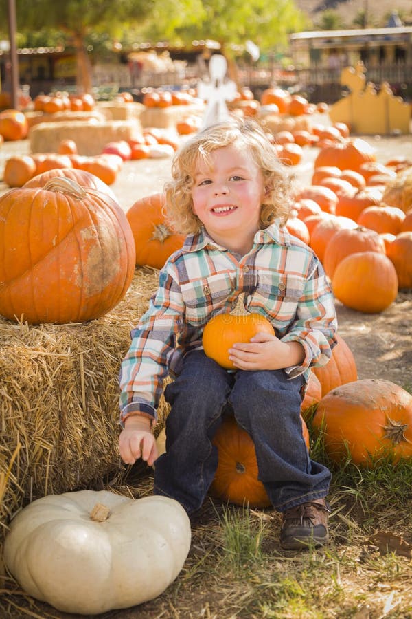 Little Boy Sitting and Holding His Pumpkin in a Rustic Ranch Setting at ...