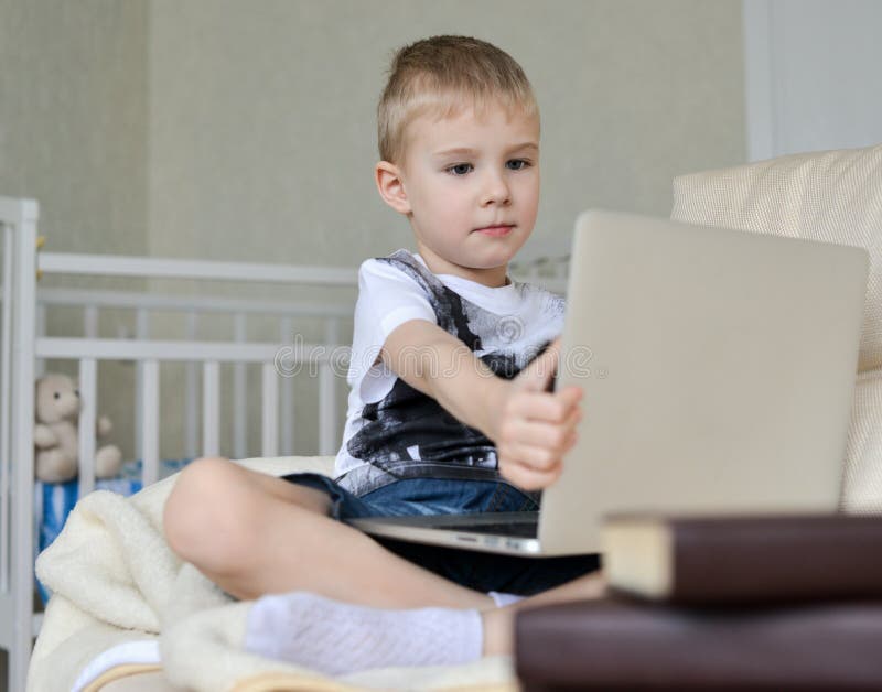 Little Boy Sitting with Laptop on the Couch at Home Stock Photo - Image ...