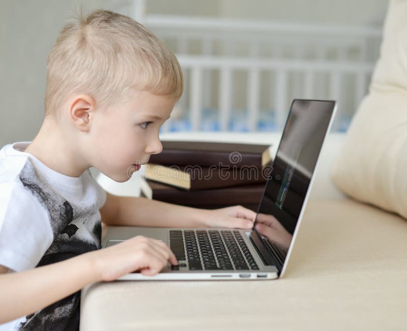 Little Boy Sitting with Laptop on the Couch at Home Stock Photo - Image ...