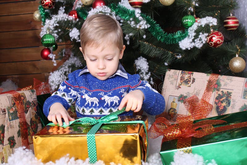 A Little Boy Sitting Under the Christmas Tree. Stock Photo - Image of ...
