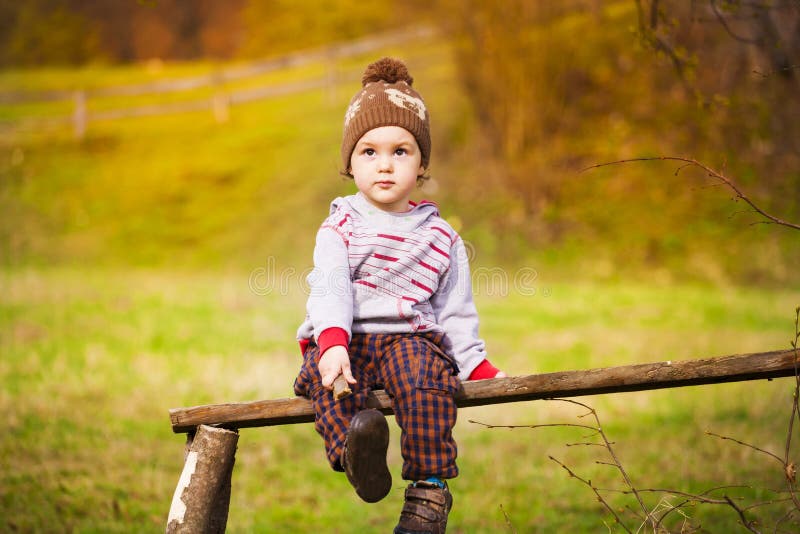 A Little Boy is Sitting Under a Tree. Stock Photo - Image of casual ...