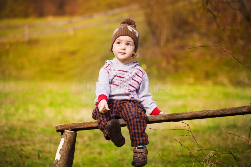 A Little Boy is Sitting Under a Tree. Stock Photo - Image of infant ...