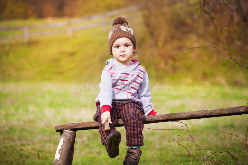 A Little Boy is Sitting Under a Tree. Stock Image - Image of childhood ...