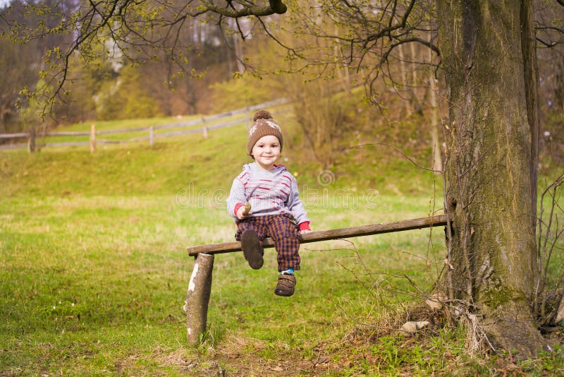 A Little Boy is Sitting Under a Tree. Stock Image - Image of child ...