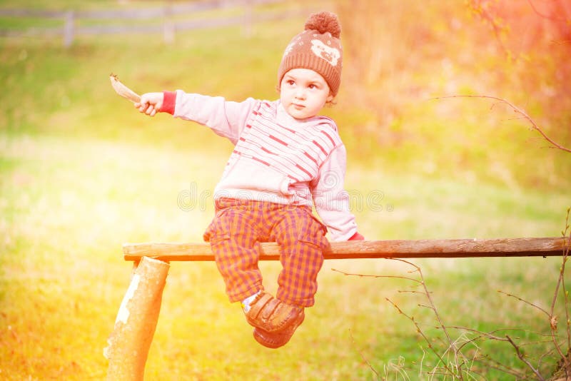 A Little Boy is Sitting Under a Tree. Stock Photo - Image of background ...