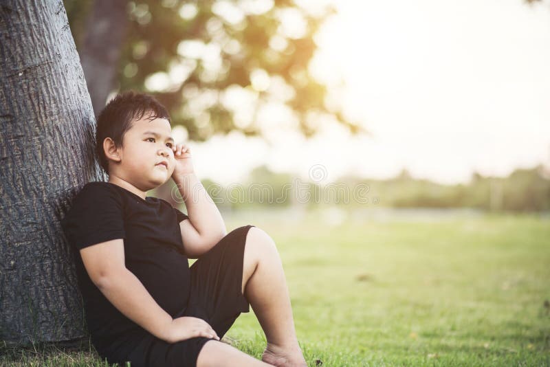 Little Boy Sitting Under the Tree Thinking Stock Photo - Image of ...