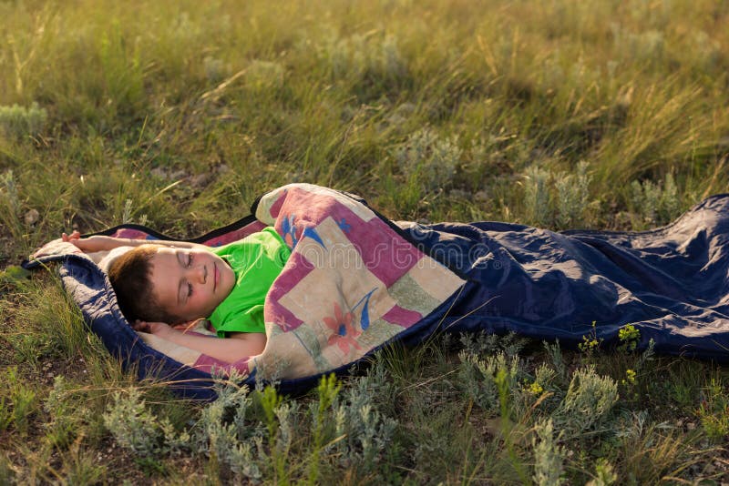 Little Boy Sleeping on the Grass, in a Sleeping Bag, Resting on a Hike ...