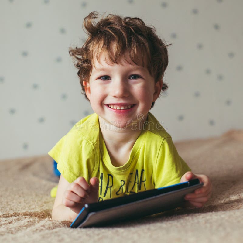 Little Boy Smiling and Looking at Tablet, Using Modern Technology ...