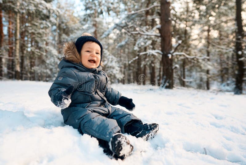 A Little Boy in the Snow. Happy Child Walking through Winter Forest ...