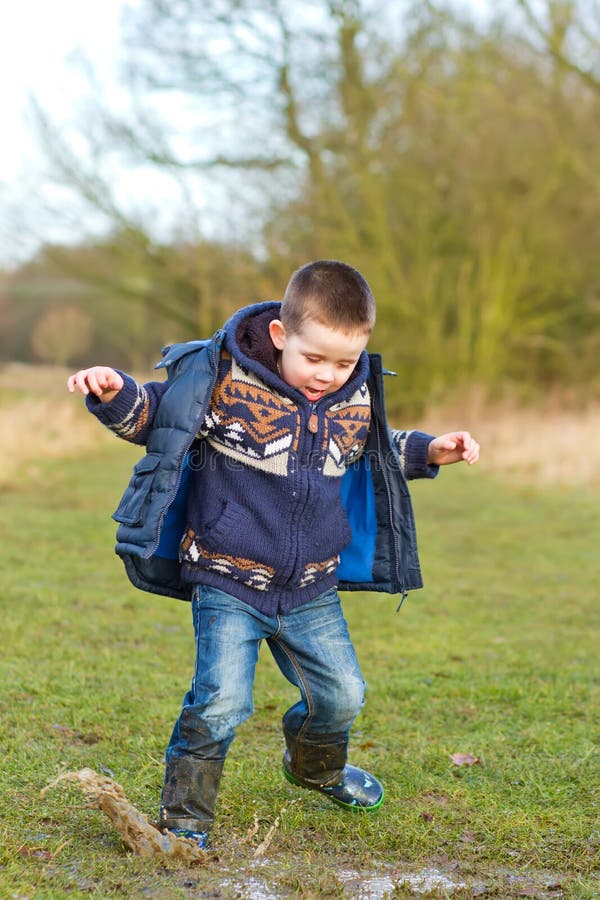 Little Boy Splashing in a Puddle in the Field Stock Image - Image of ...