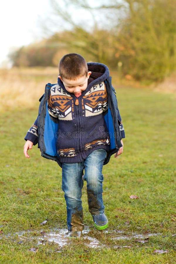 Little Boy Splashing in a Puddle in the Field Stock Image - Image of ...