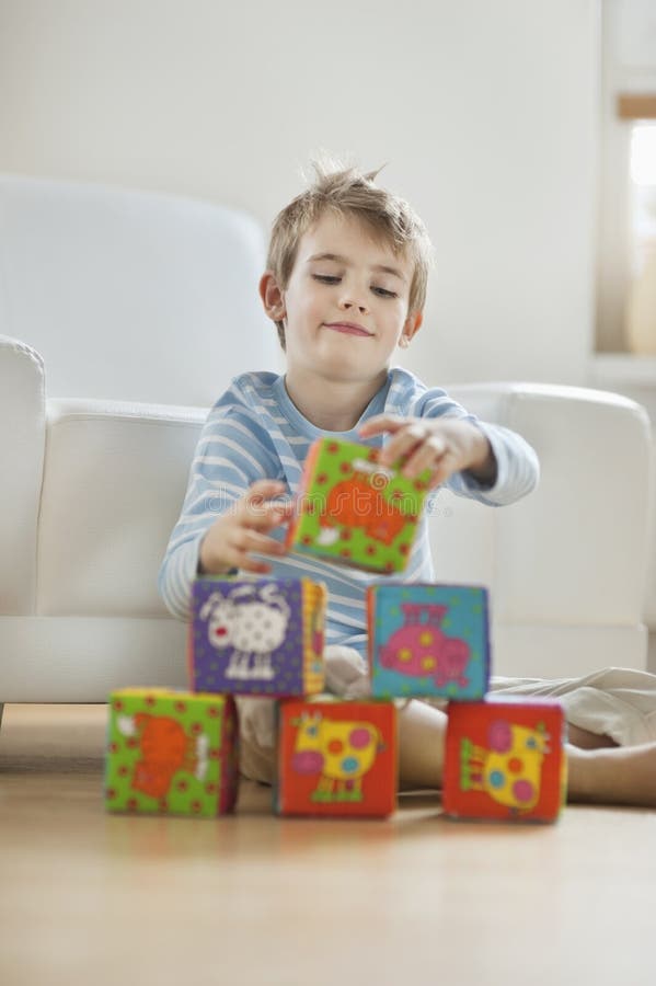 Little Boy Stacking Blocks while Sitting on Floor Stock Image - Image ...