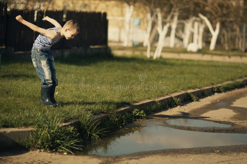 Little Boy Standing in Puddle Stock Image - Image of little, laugh ...