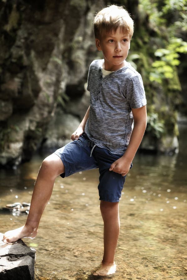 Little Boy Standing on the Rock in the River Stock Image - Image of ...