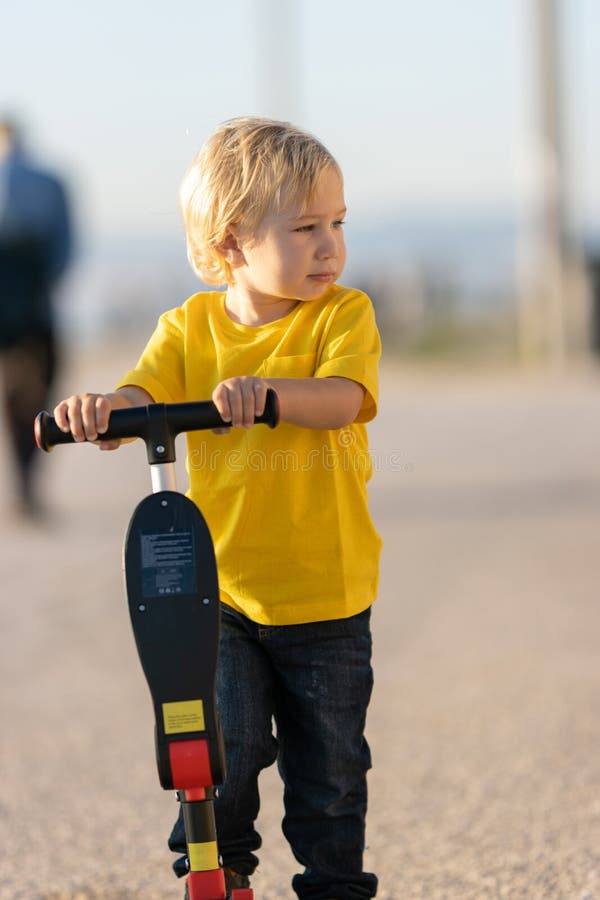 A Little Boy Stands on the Road Holding by a Scooter Stock Photo ...