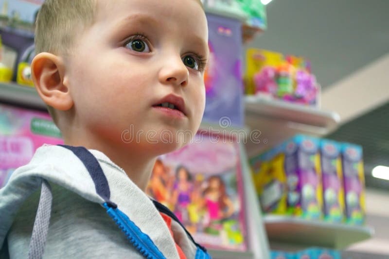 Little Boy in the Store Chooses and Buys Toys. Stock Image - Image of ...
