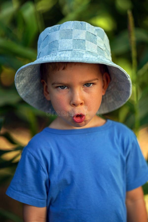 A Little Boy in Summer Clothes with a Menacing Expression on His Face ...
