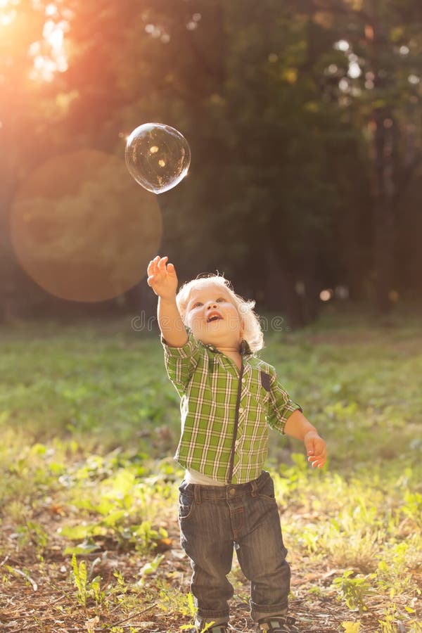 Little Boy in the Sunset Catches Soap Bubbles Stock Image - Image of ...