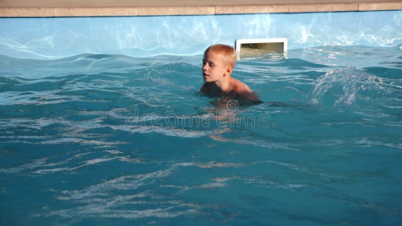 A Little Boy Swims in a Deep Pool Alone, he Dives and Swims Underwater ...