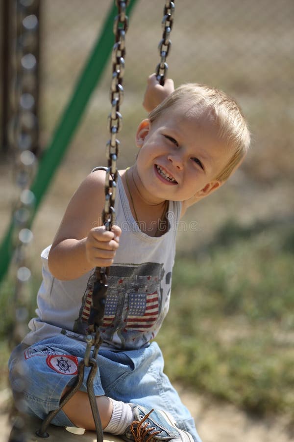 Little boy on a swing stock photo. Image of offspring - 47981488