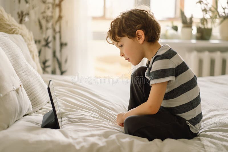 Little Boy with a Tablet in the Room. the Boy Play Game on the Tablet ...