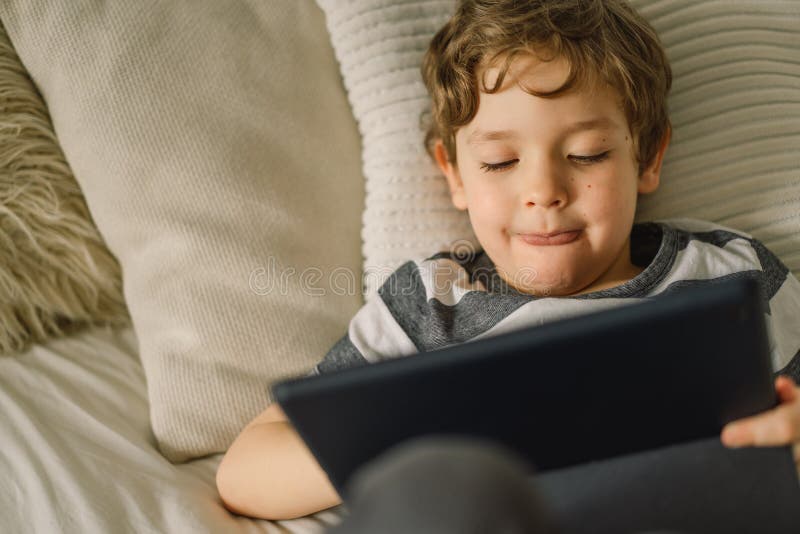 Little Boy with a Tablet in the Room. the Boy Play Game on the Tablet ...
